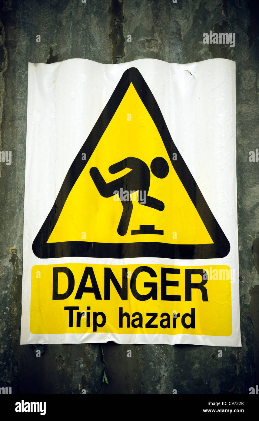 yellow triangular danger trip hazard warning sign Stock Photo - Alamy