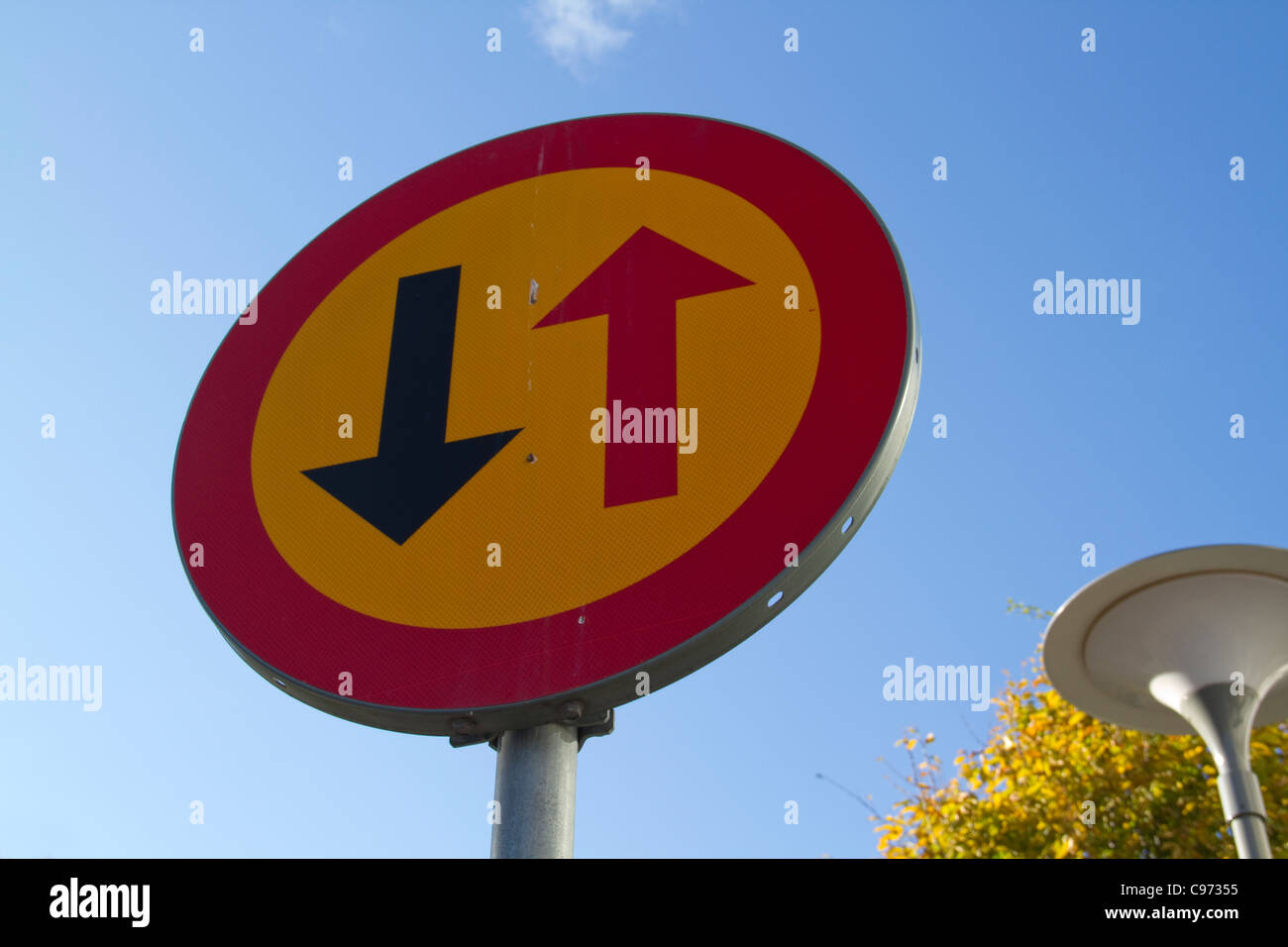 Road sign showing arrows with other lane priority Stock Photo - Alamy