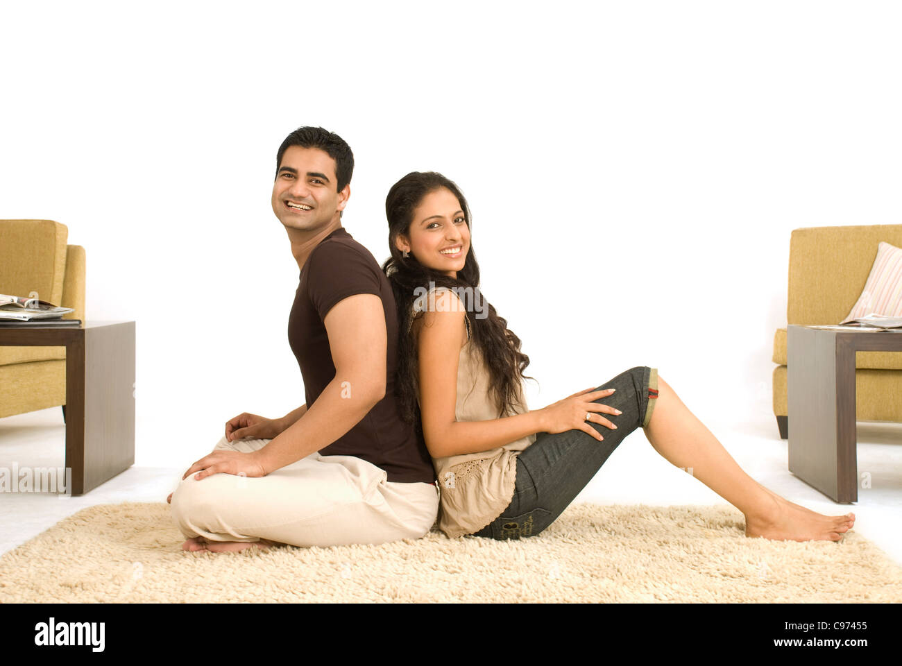 Couple sitting back to back Stock Photo - Alamy