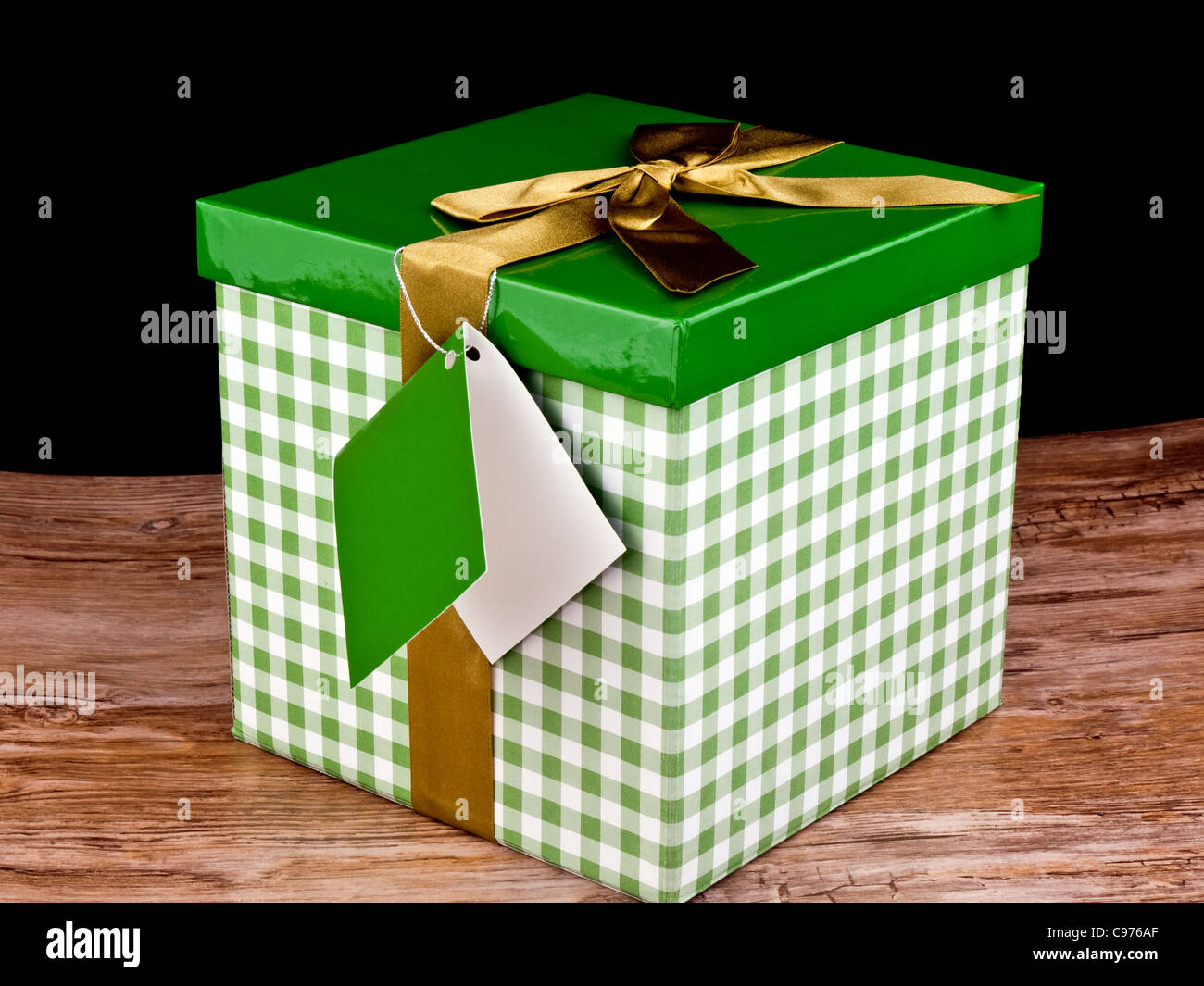 Big green gift box with golden ribbon on wooden table Stock Photo - Alamy