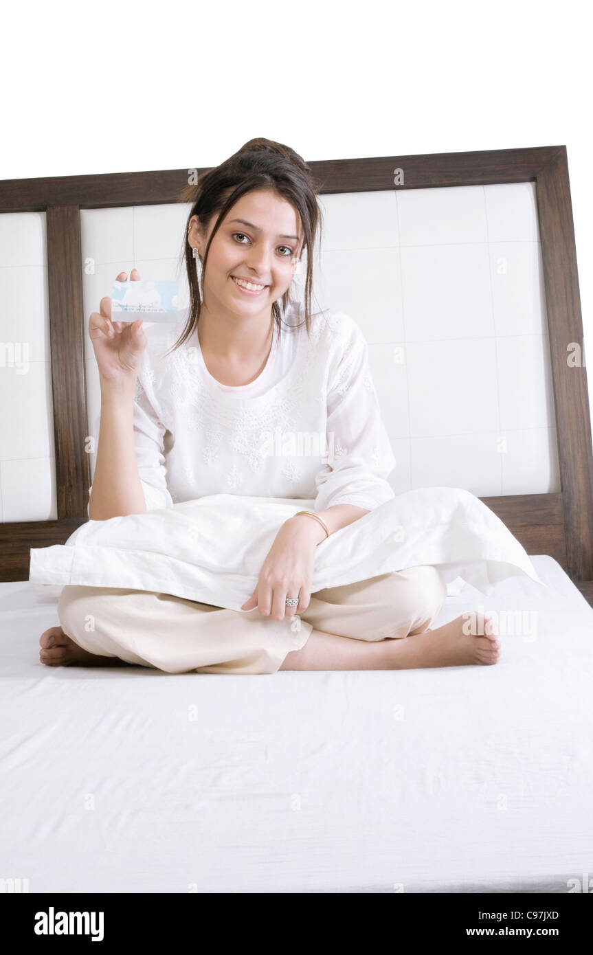 lady sitting on the bed and holding a card Stock Photo - Alamy