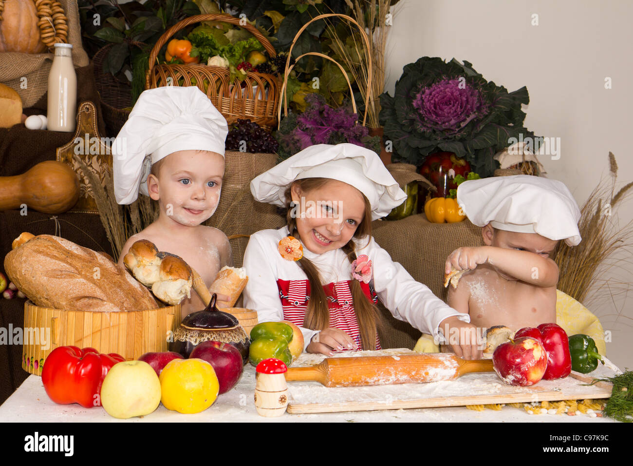 Happy cute kids cooking in chefs hats Stock Photo - Alamy