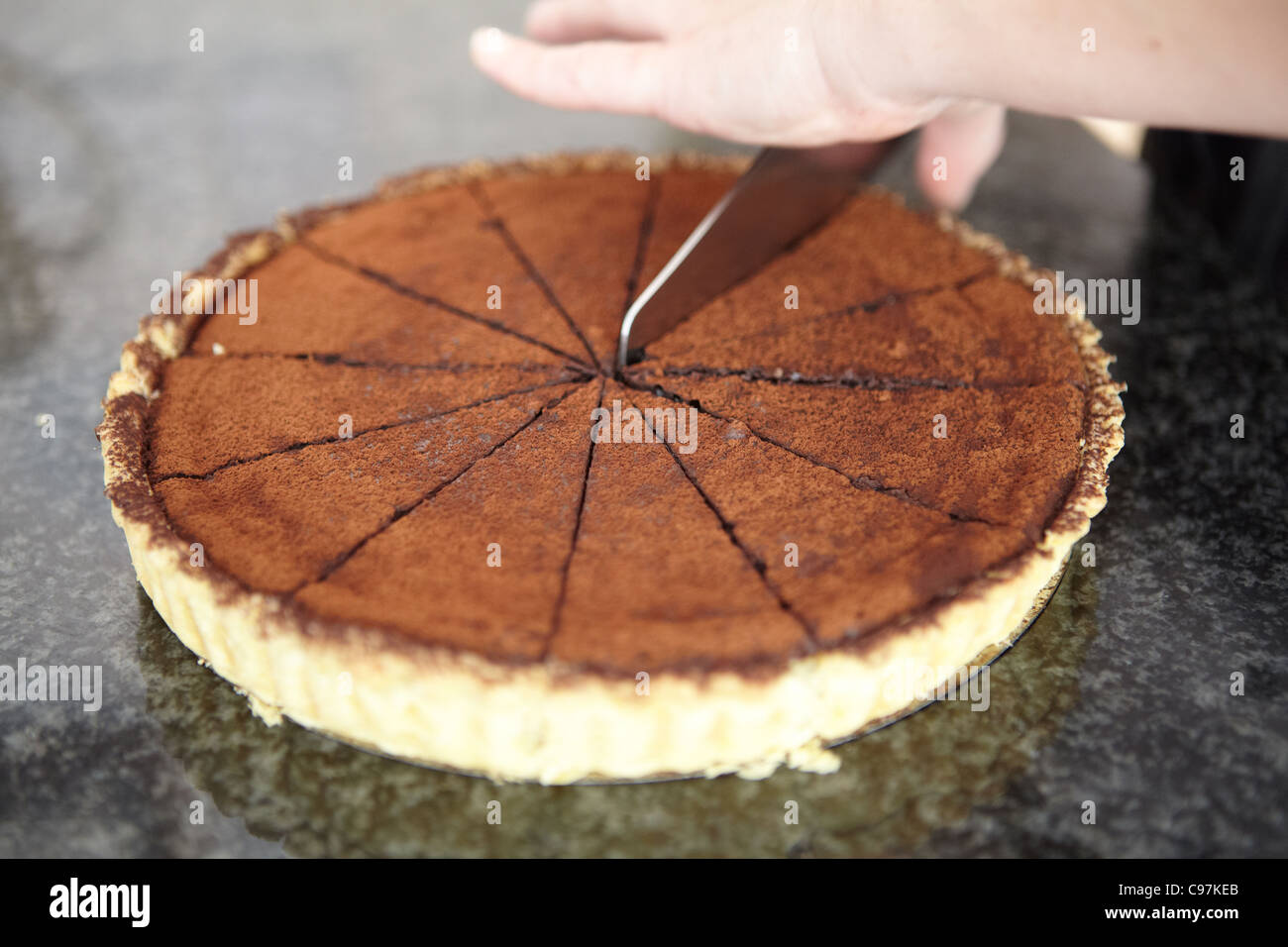 Freshly baked chocolate torte marked into slices ready to be cut with a ...