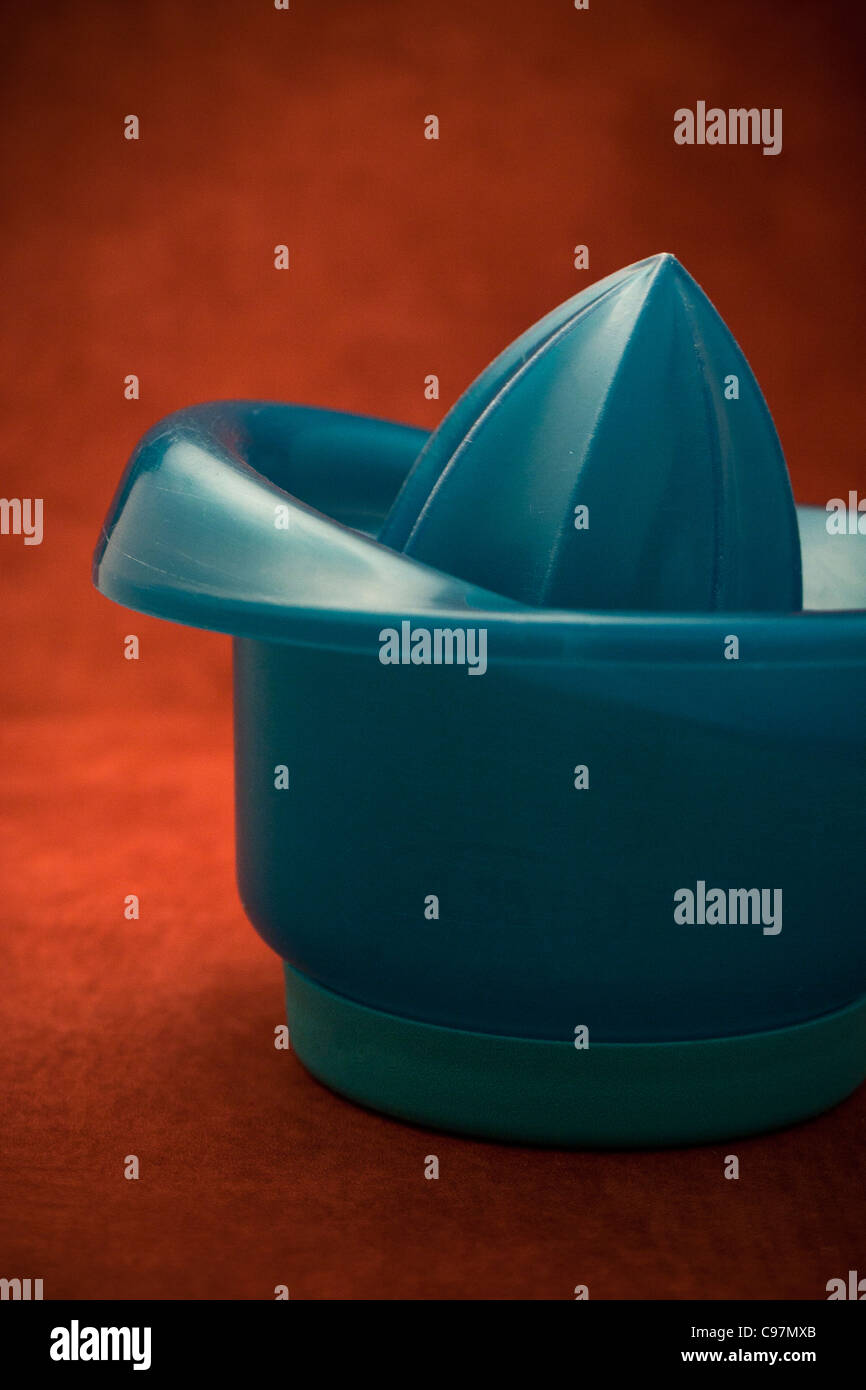 green lemon juicer against red background Stock Photo - Alamy