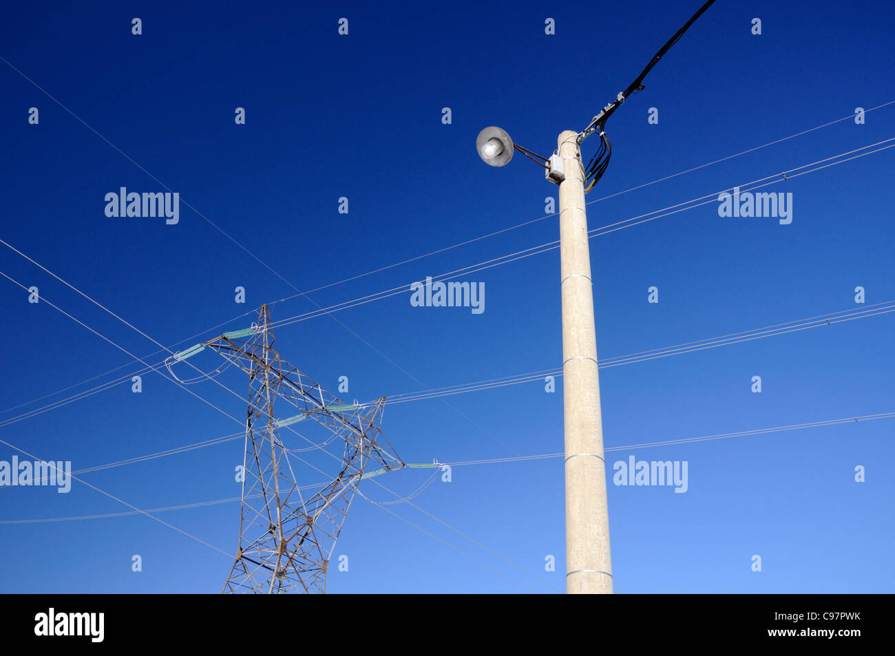 Power pylon and street lamp against blue sky Stock Photo - Alamy