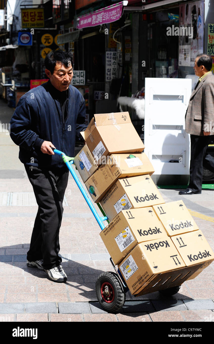 An asian man pushing sack of boxes in busan hi-res stock photography ...