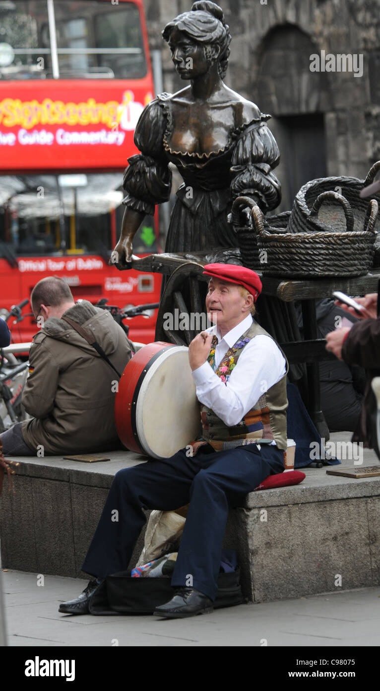 A BUSKER PLAYS IN FRONT OF THE MOLLY MALONE STATUE IN DUBLIN Stock ...
