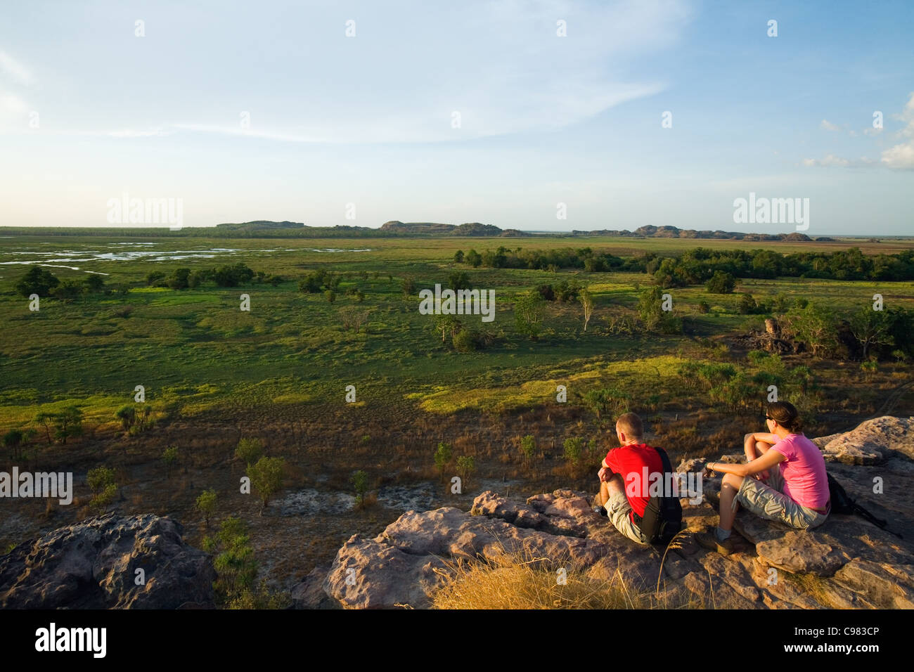 A couple look out over the Nadab floodplain from the sacred Aboriginal site of Ubirr. Kakadu ...