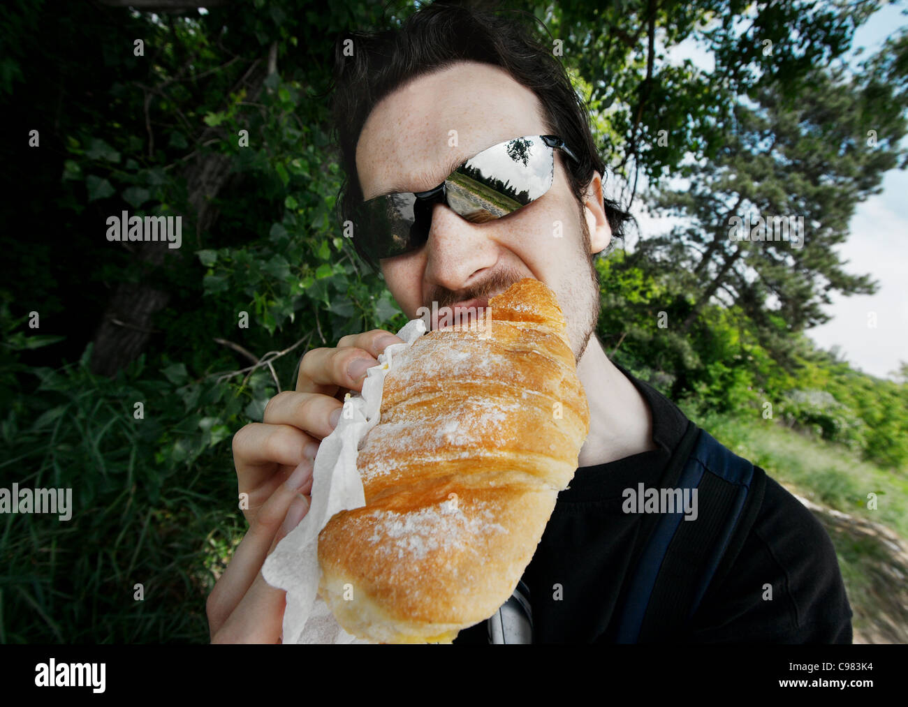 Portrait of a man biting huge of his food Stock Photo - Alamy