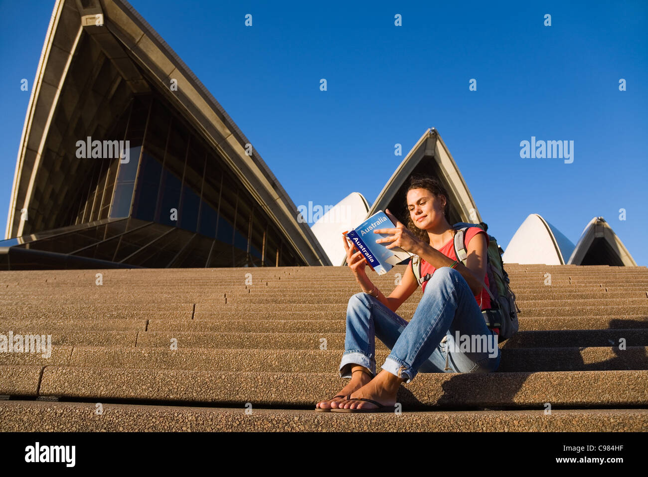 Tourist reading guidebook on steps of the Sydney Opera House. Sydney ...