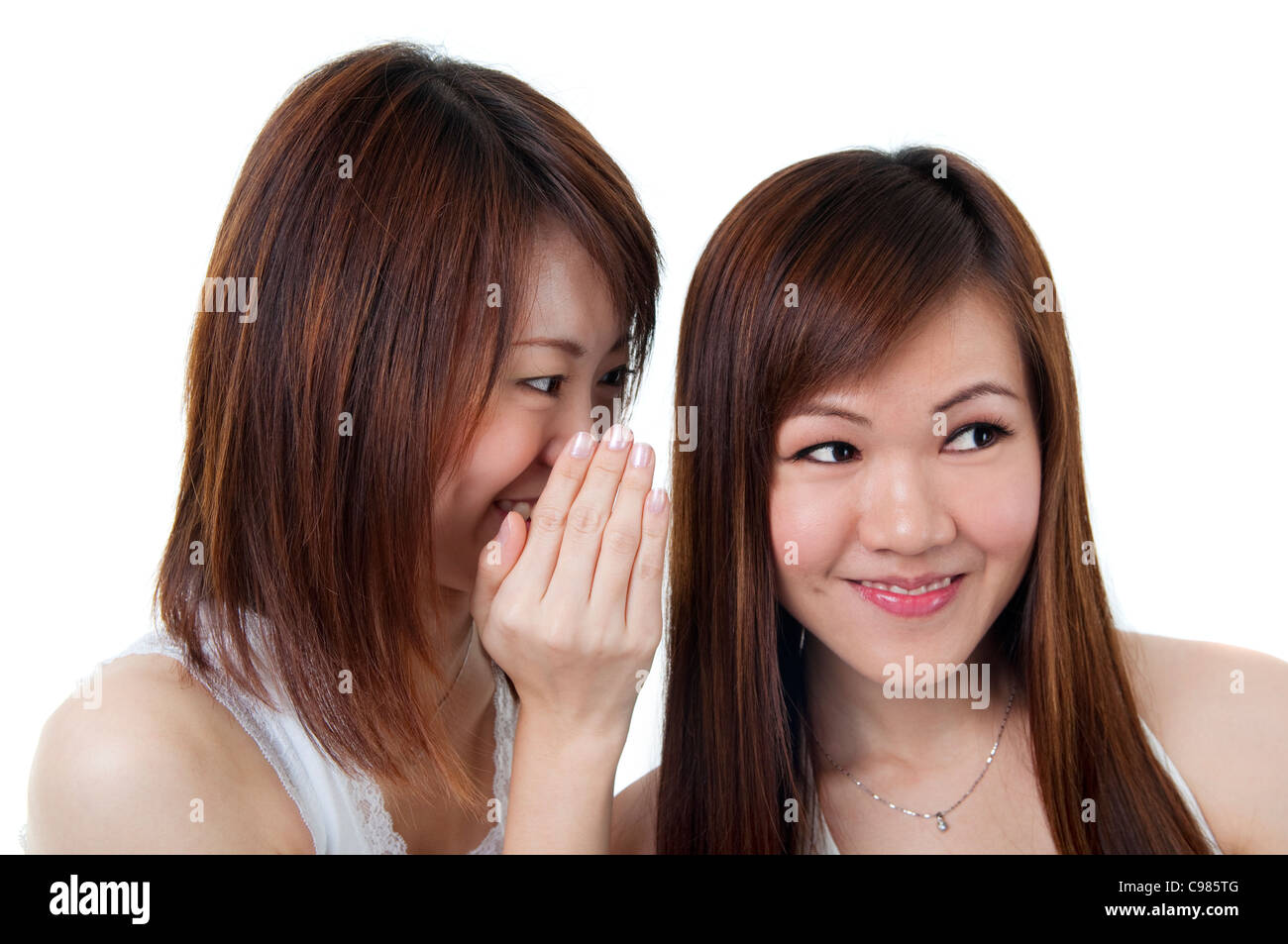 Two happy asian friends talking over white background Stock Photo - Alamy