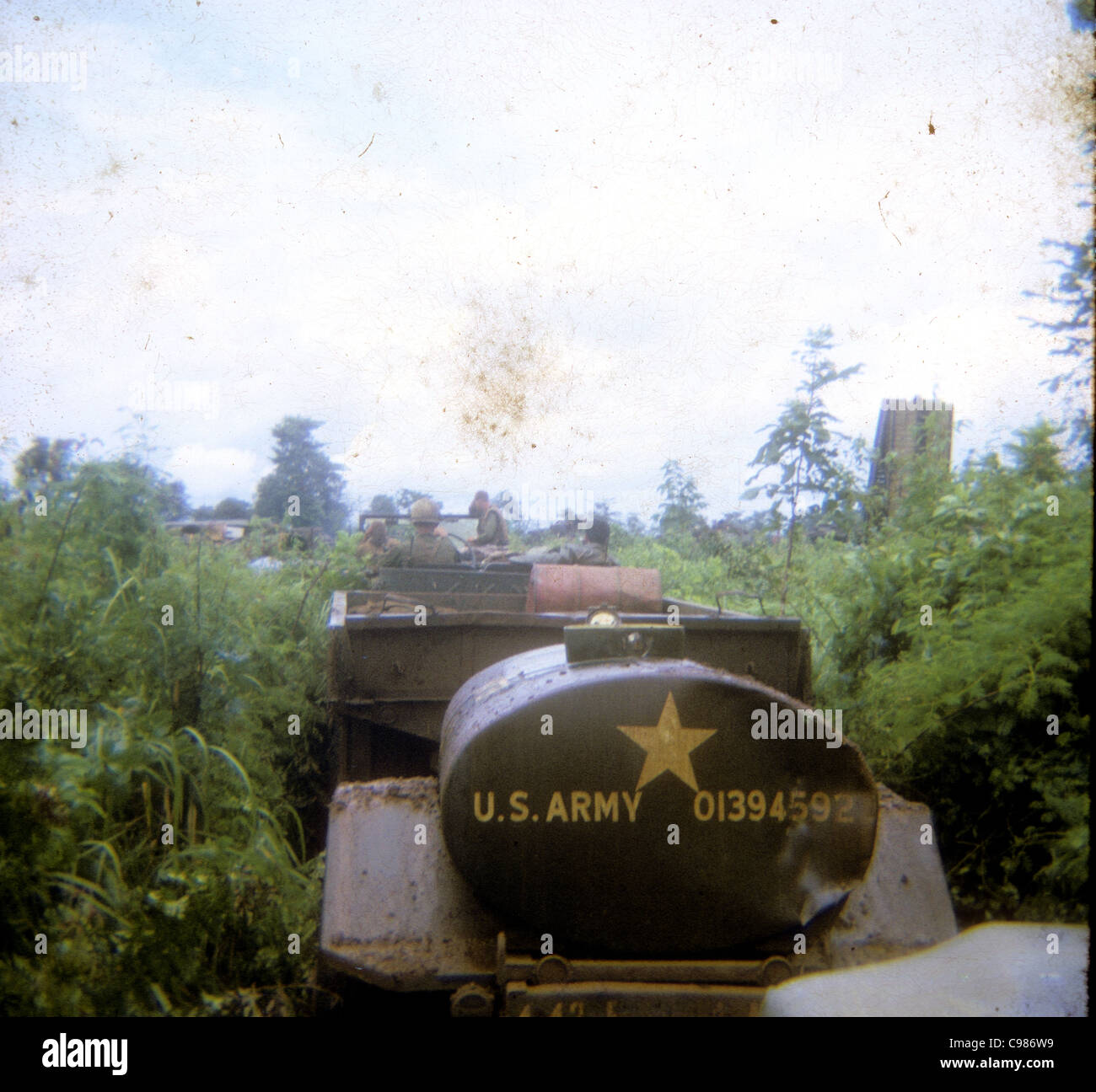 US GIs riding through jungle with tanker Stock Photo - Alamy
