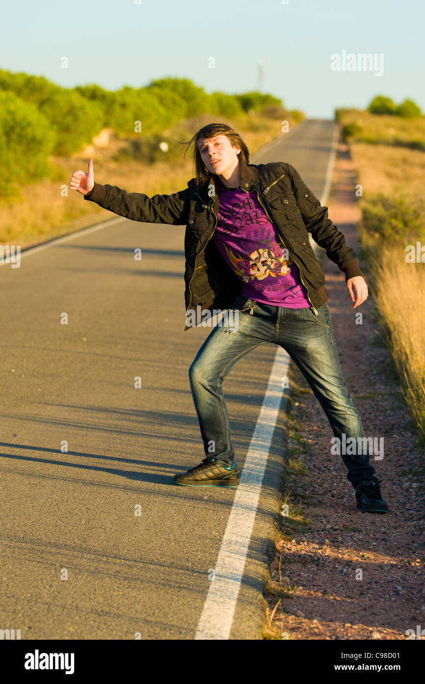 Hitchhiking youngster quite desperate to get a lift Stock Photo - Alamy