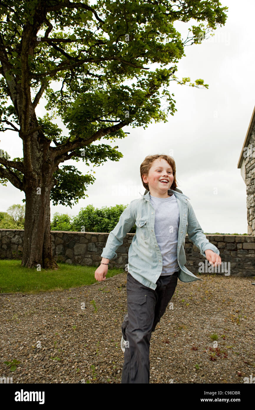 Boy running across gravel Stock Photo - Alamy
