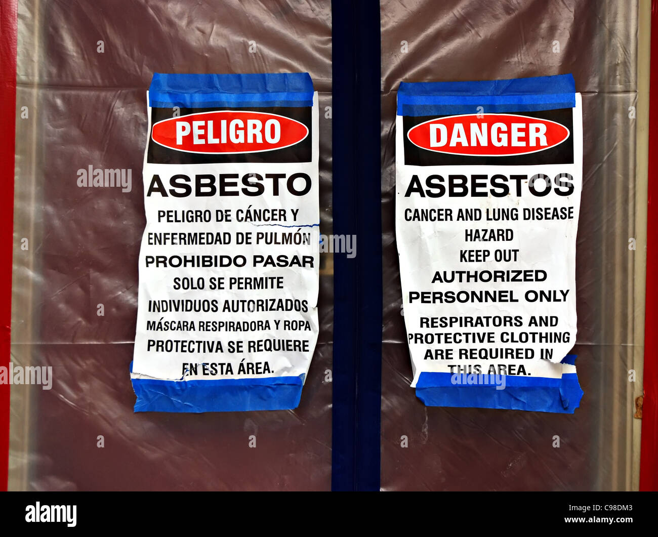 Bilingual asbestos warning signs on plastic covering a front door Stock ...
