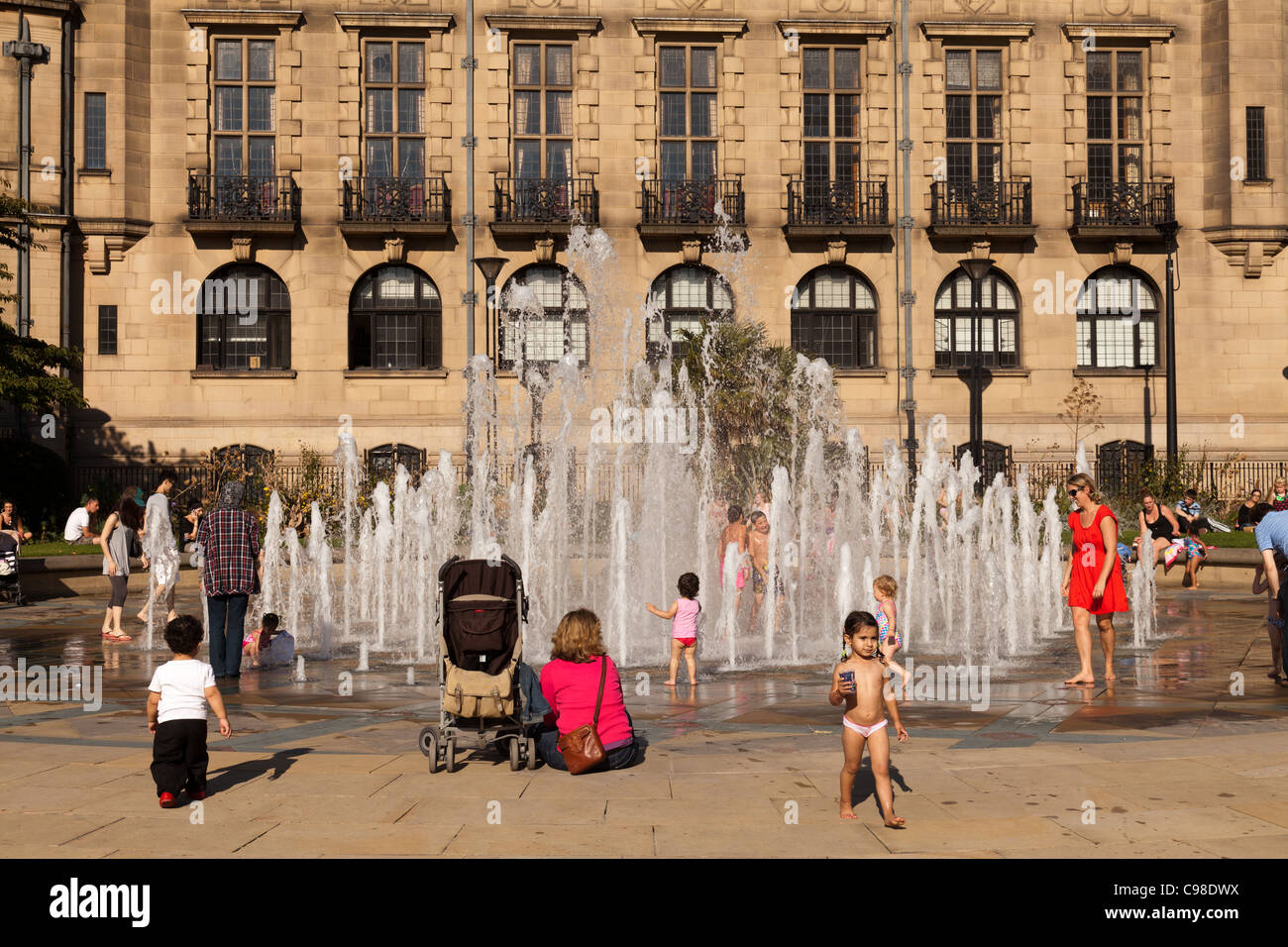 Children playing in the fountains and enjoying the sunshine in the ...