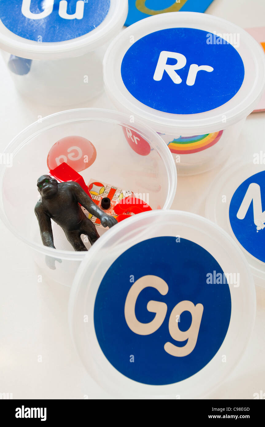 Plastic container with toy gorilla and letter g on lid Stock Photo - Alamy