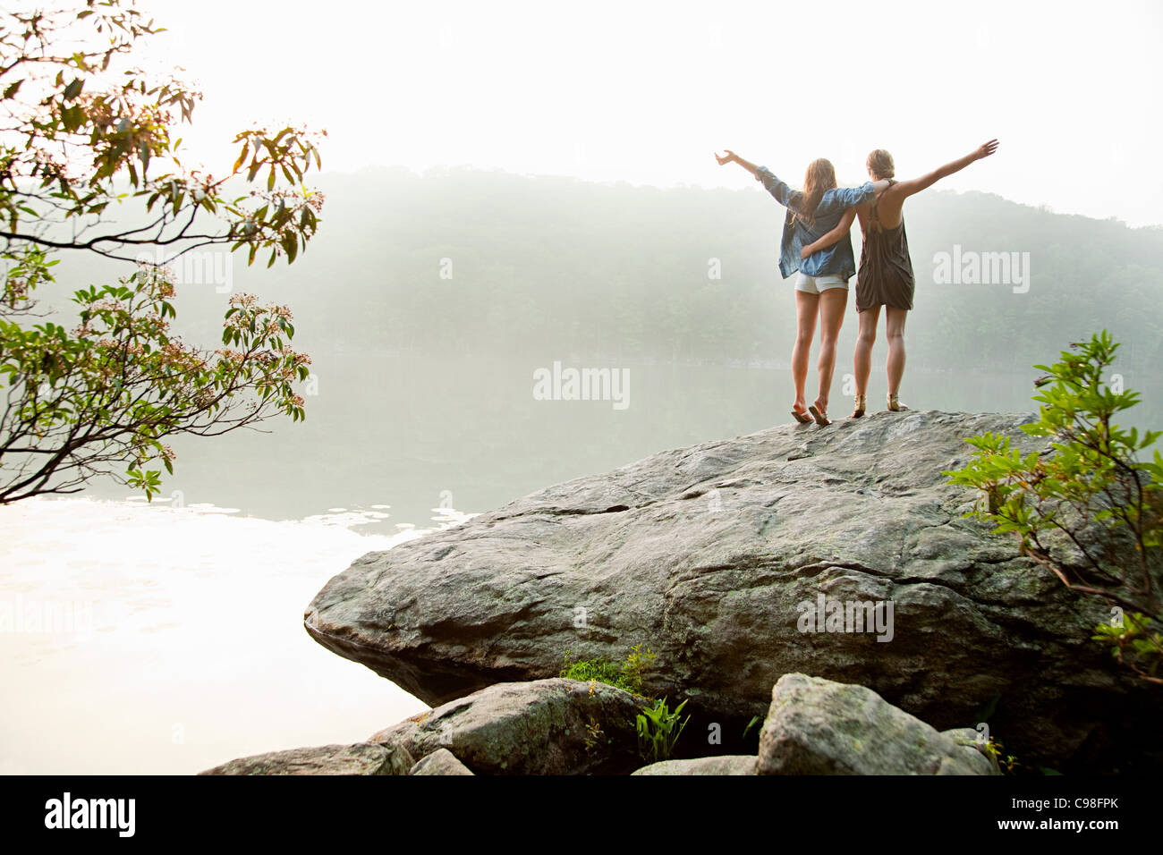 Young women looking over lake Stock Photo - Alamy