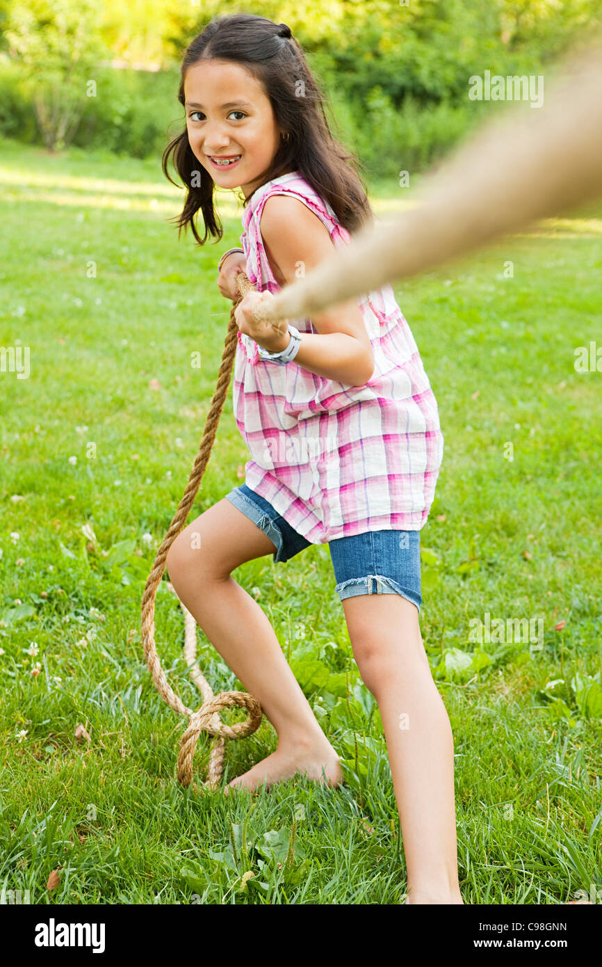 Girl pulling rope game tug war Stock Photo - Alamy
