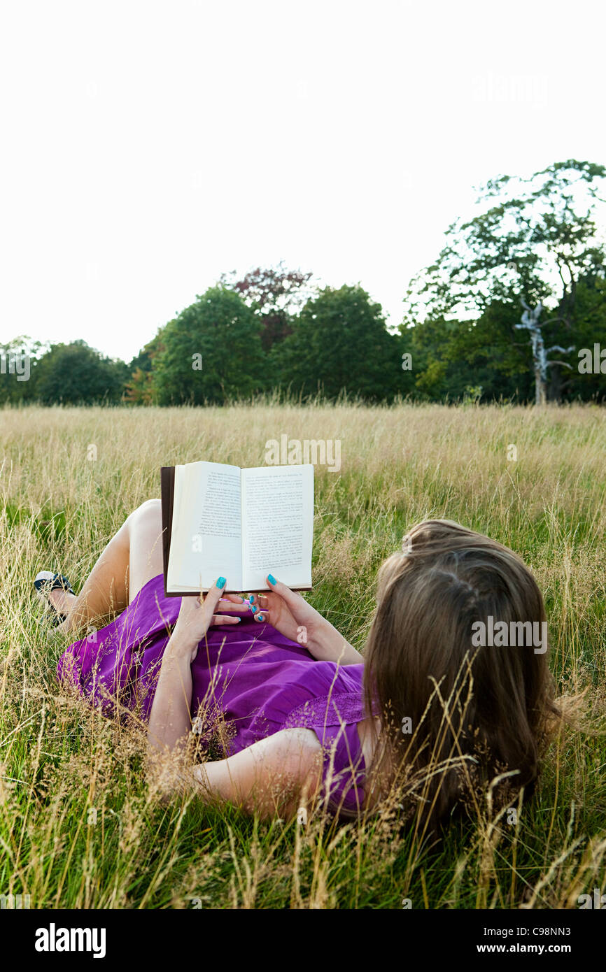 Young woman reading book field Stock Photo - Alamy