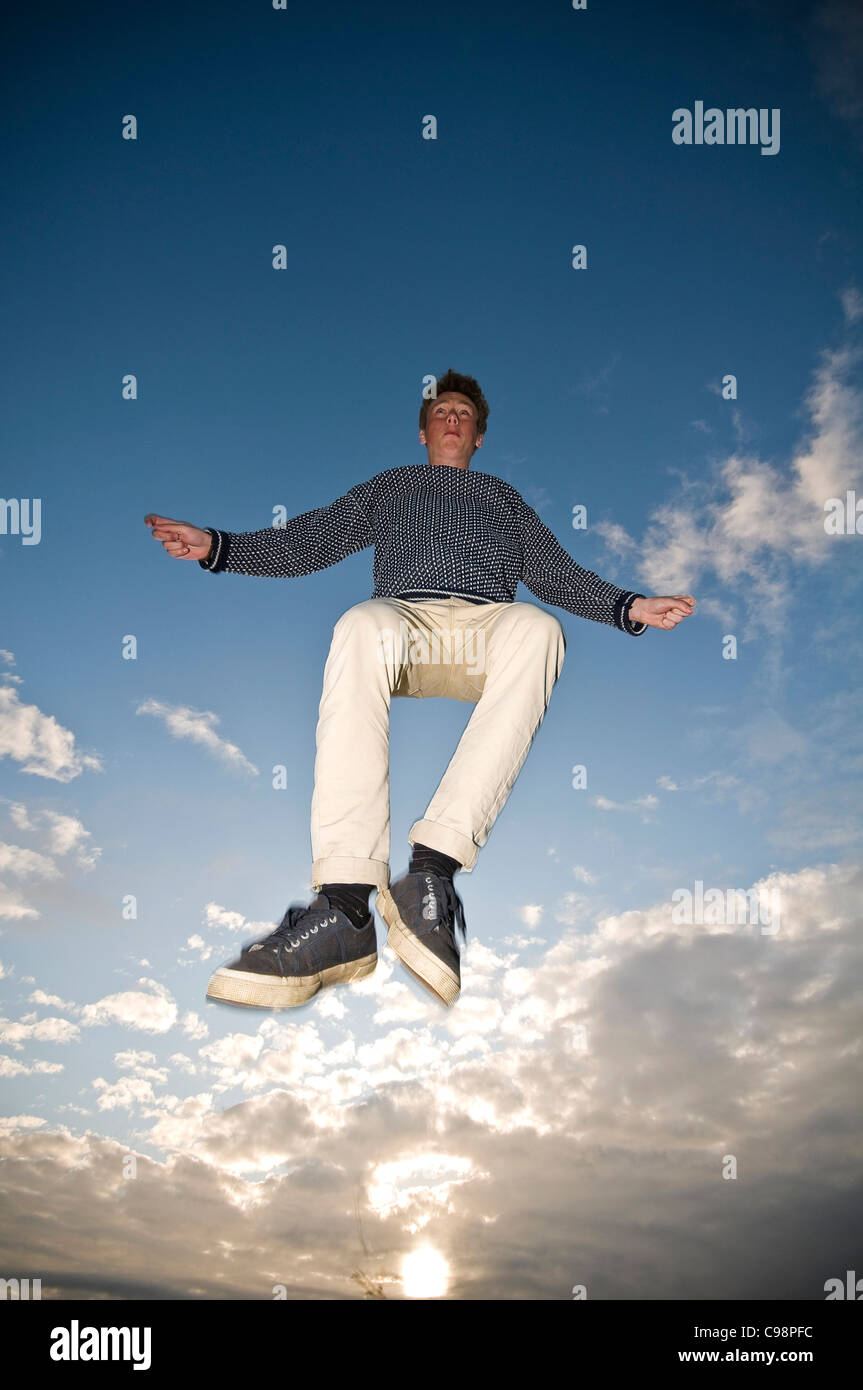 Young man leaping in the air viewed from beneath Stock Photo - Alamy