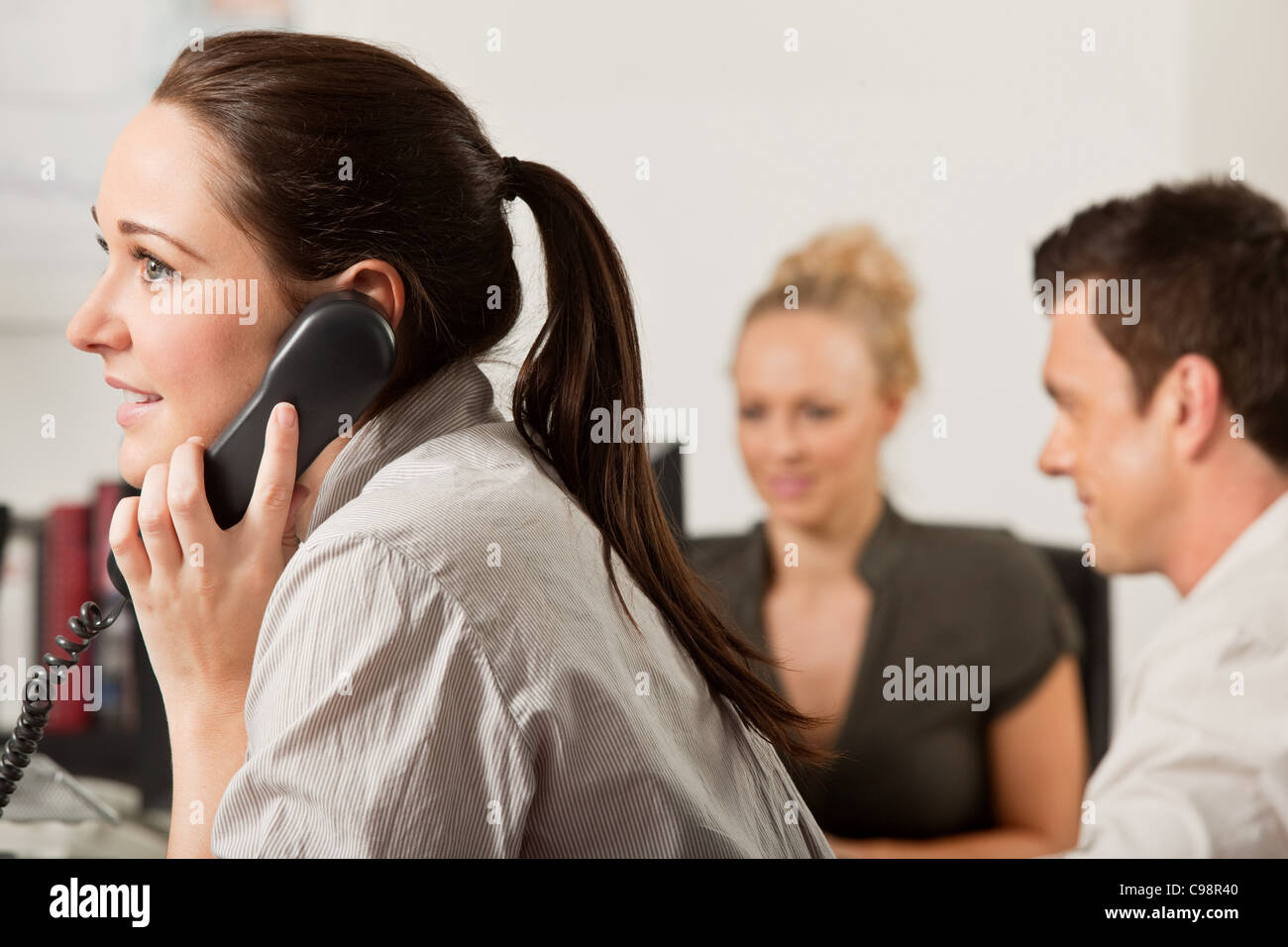 Female employee using telephone office Stock Photo - Alamy