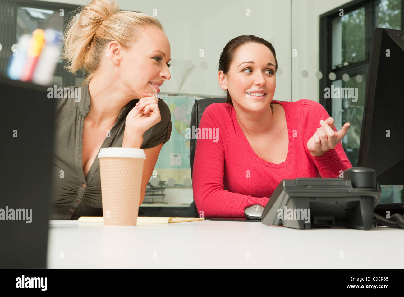 Two female employees looking computer Stock Photo - Alamy