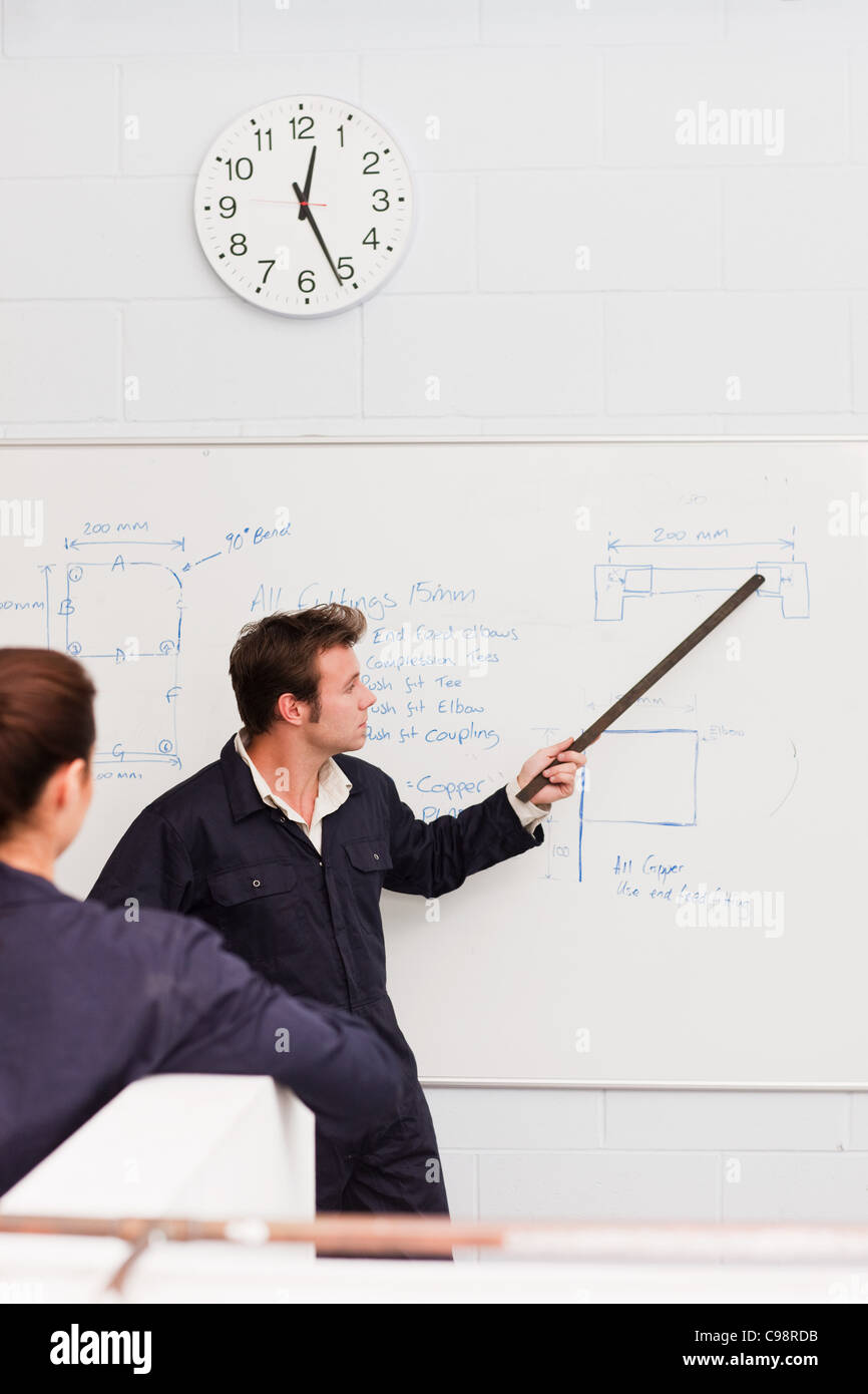 Professional plumber teaching apprentice front whiteboard Stock Photo ...