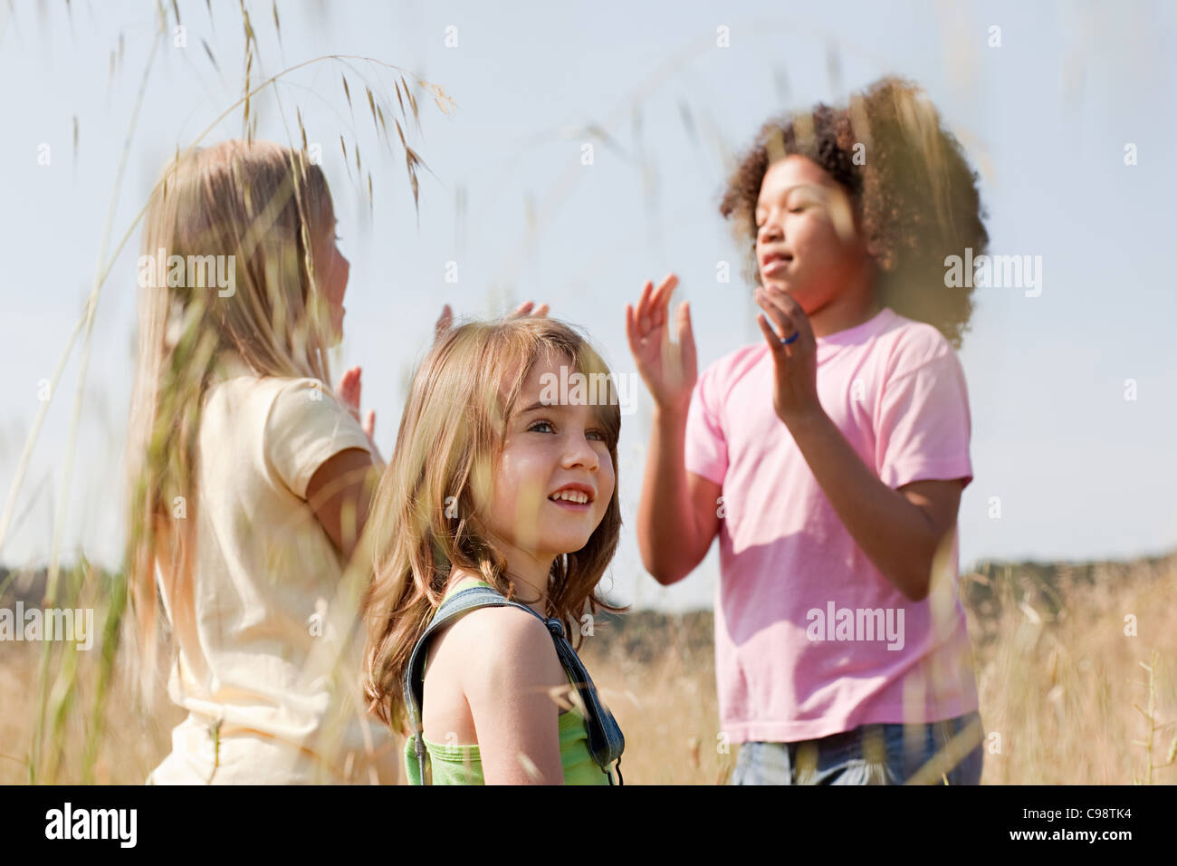 Girls playing pat a cake in field Stock Photo - Alamy