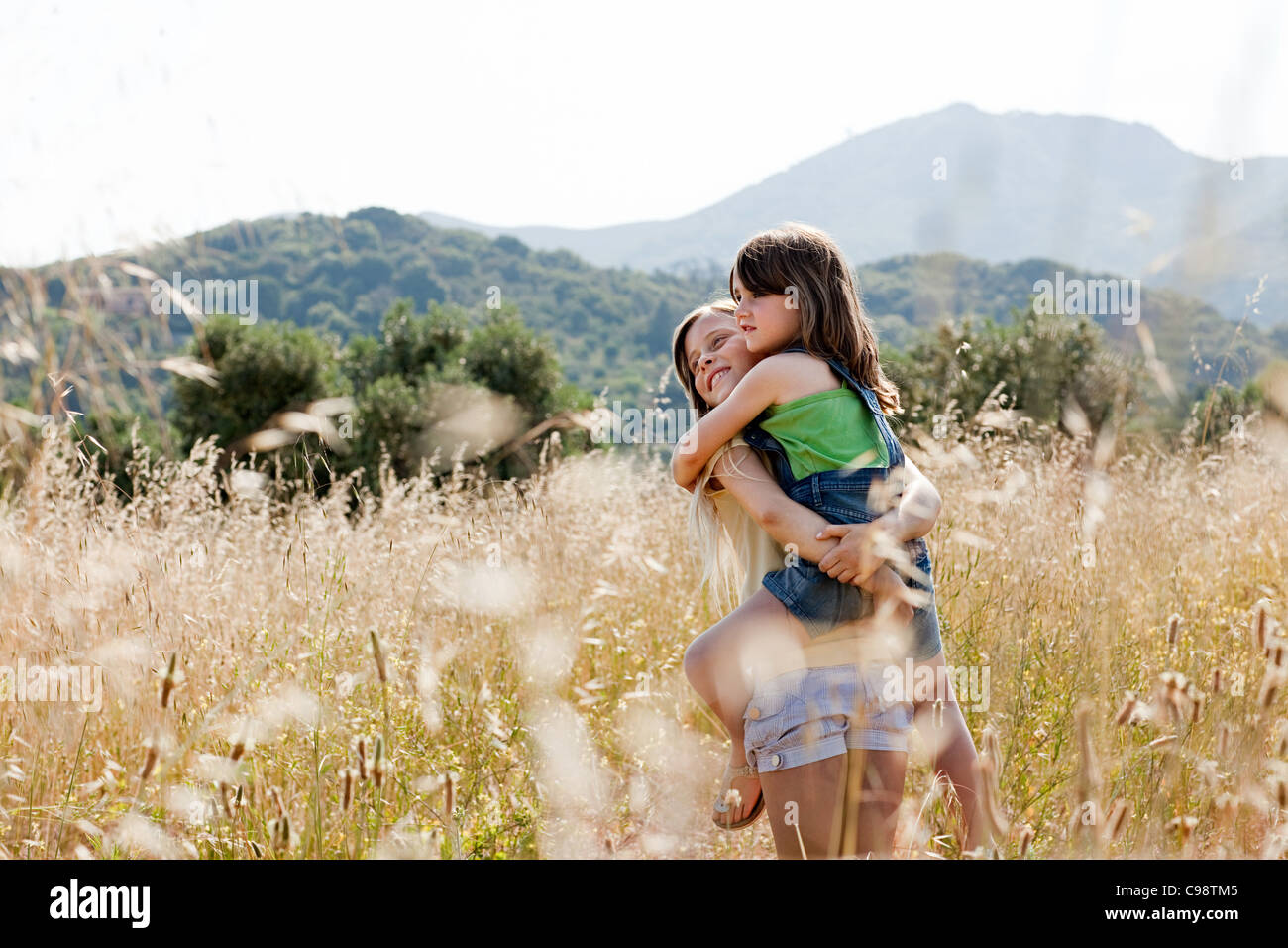 Girl carrying friend in field Stock Photo - Alamy Girl carrying friend in field Stock Photo - Alamy