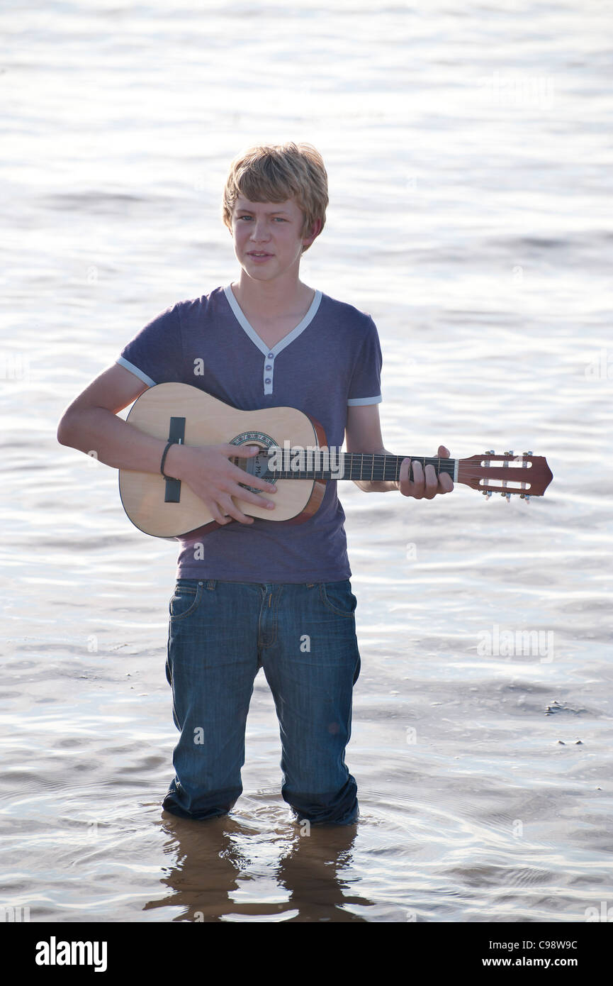 teenage boy standing in the sea play a guitar Stock Photo - Alamy