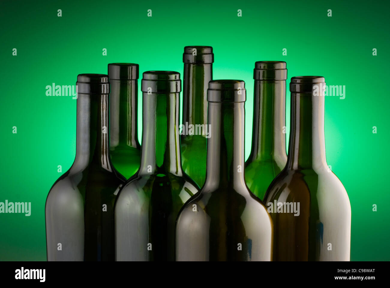 Red wine bottles on green background Stock Photo - Alamy