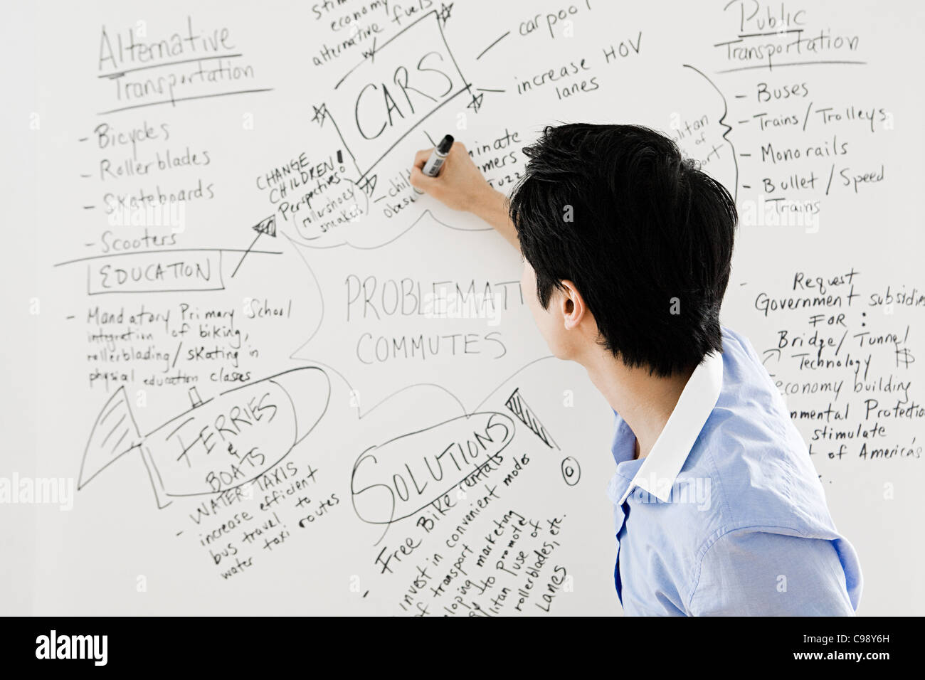 Young man writing on whiteboard Stock Photo - Alamy