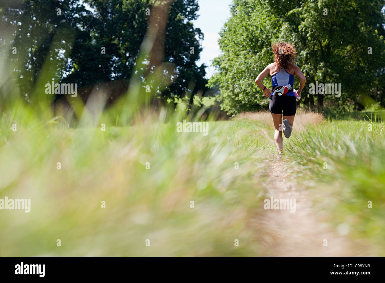 Woman running along path Stock Photo - Alamy