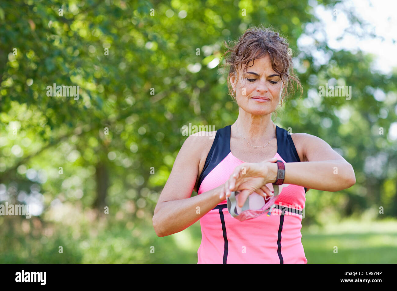 Woman checking watch during exercise Stock Photo - Alamy