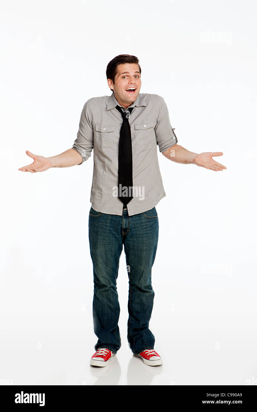 Young man shrugging shoulders against white background Stock Photo - Alamy