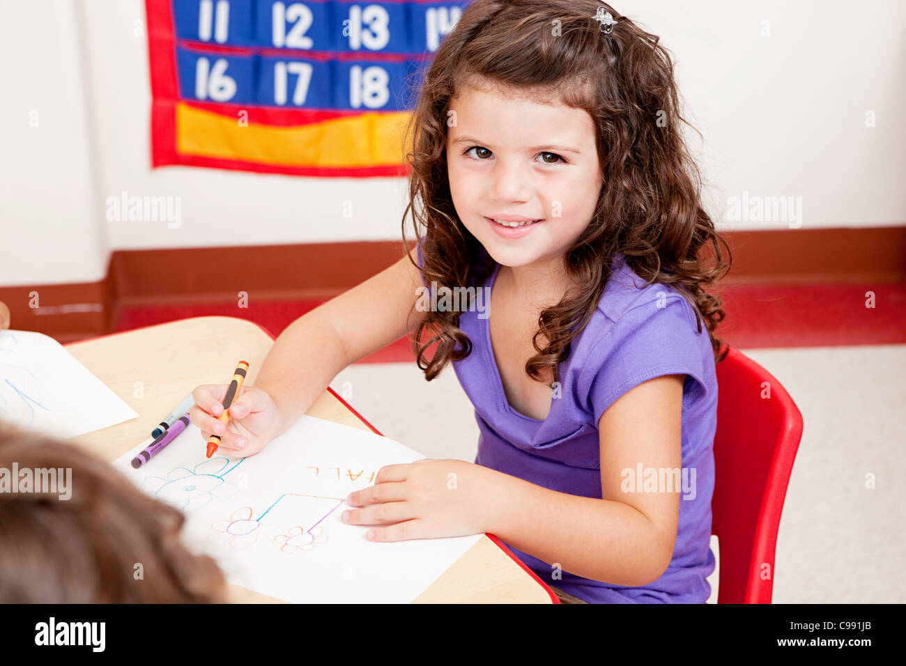 Girl drawing a picture in class Stock Photo - Alamy