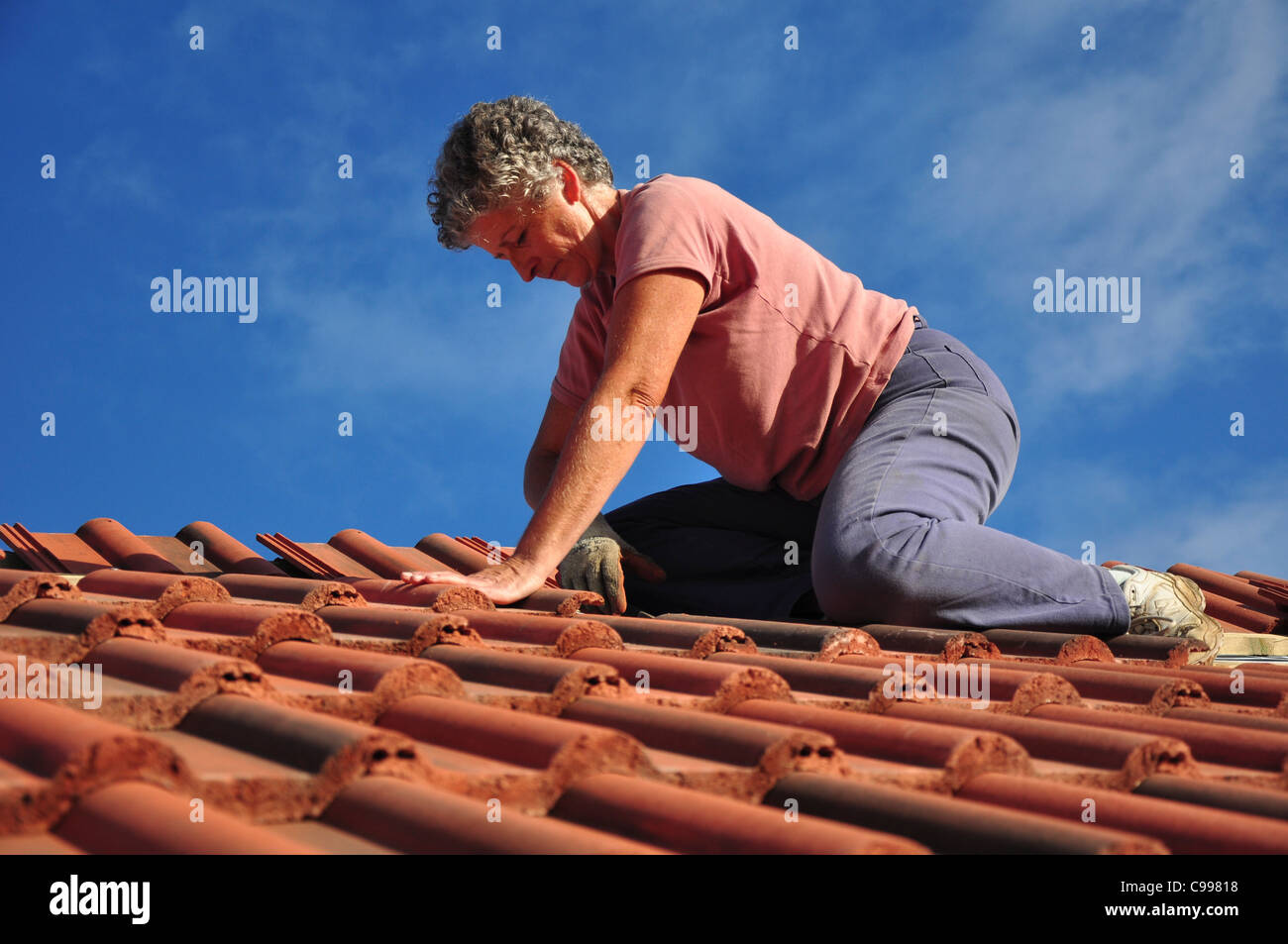 Lady fixing double roman tiles on roof Stock Photo - Alamy