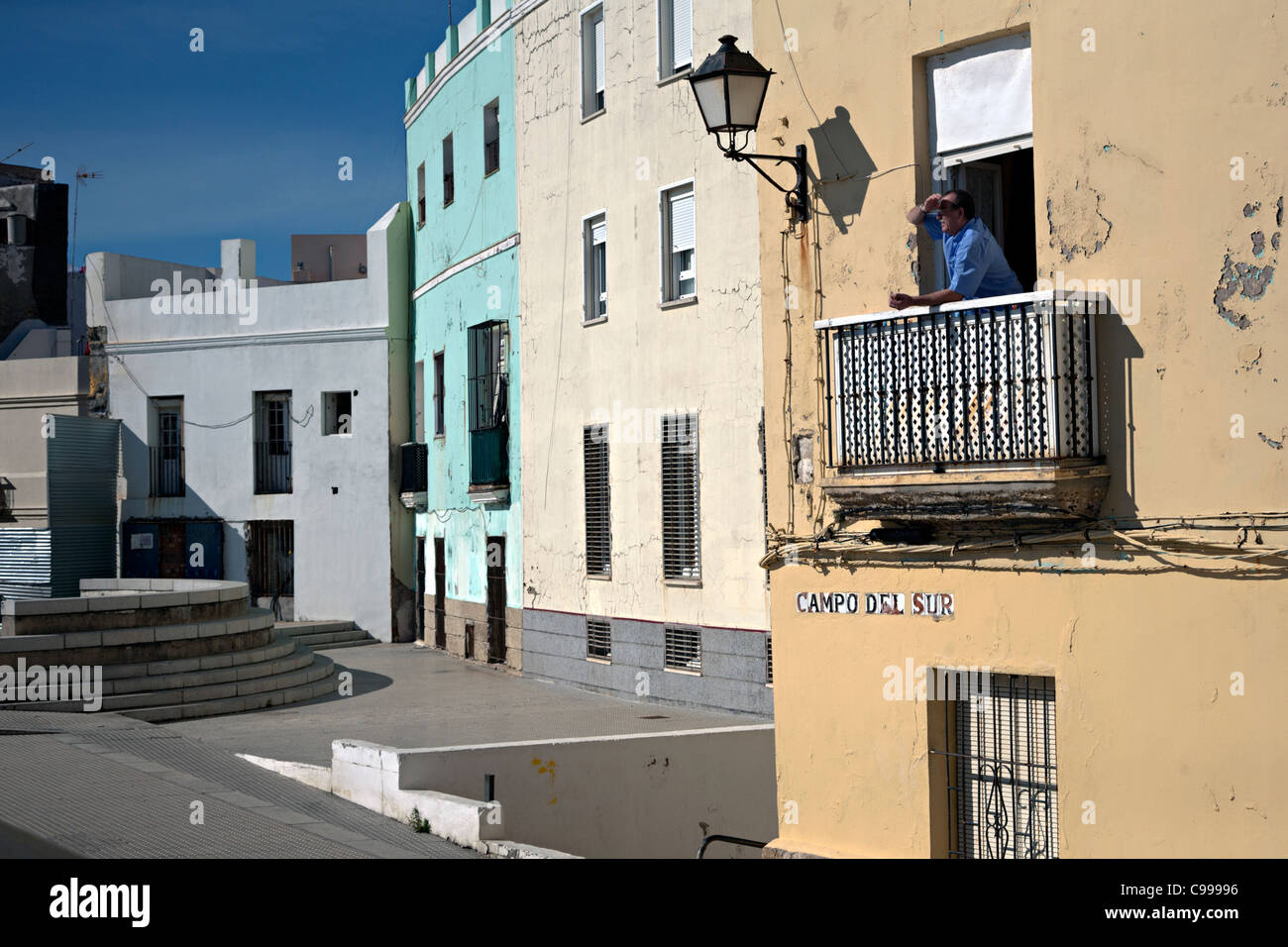 man looks outside his window in cadiz spain Stock Photo - Alamy