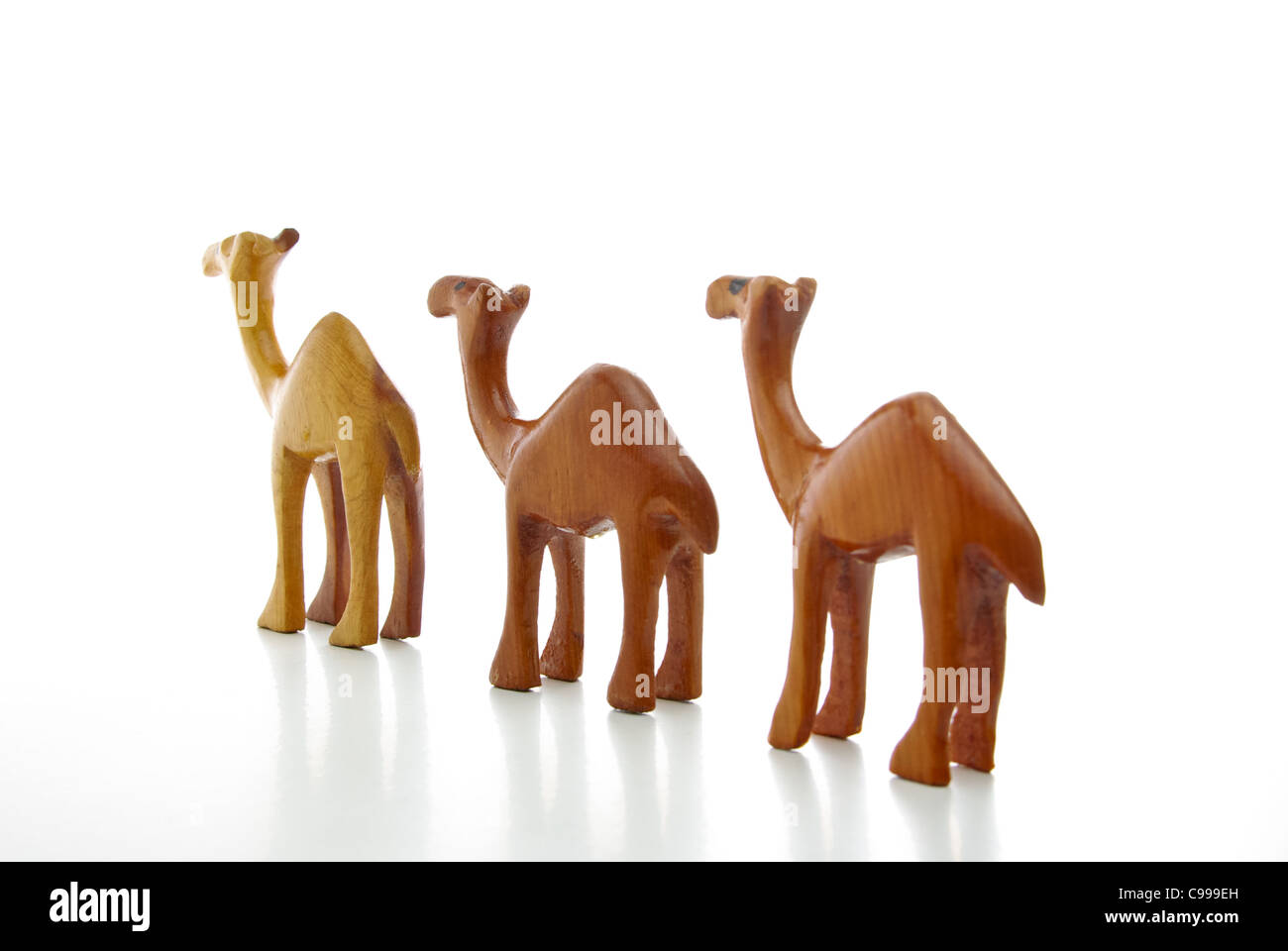 Three wooden camels isolated on a white background Stock Photo - Alamy