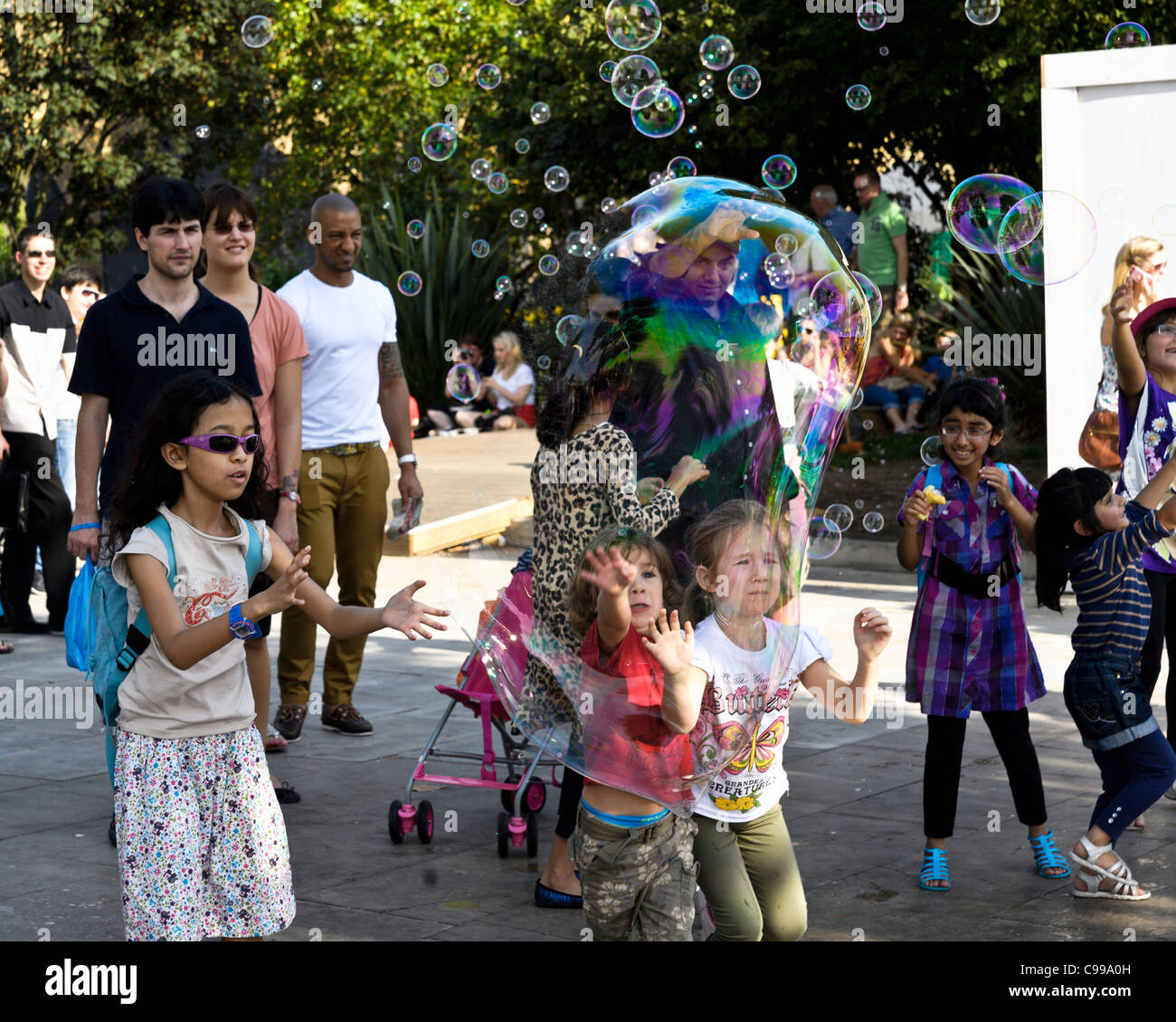 A Young children look worried as they pop a very large bubble on the ...