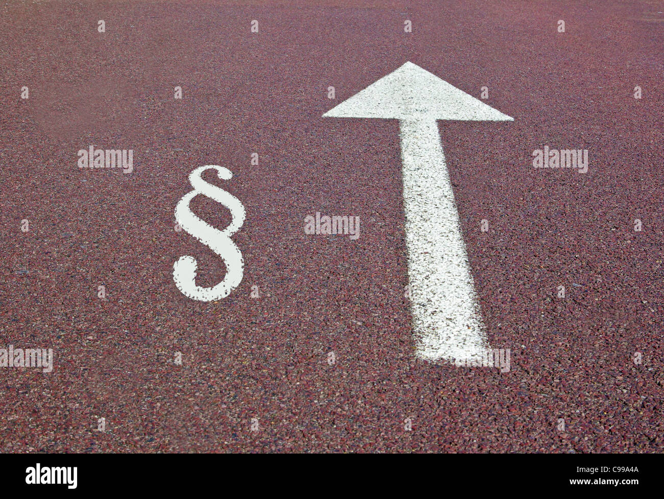 an arrow on the asphalt showing the direction with the law sign near it ...