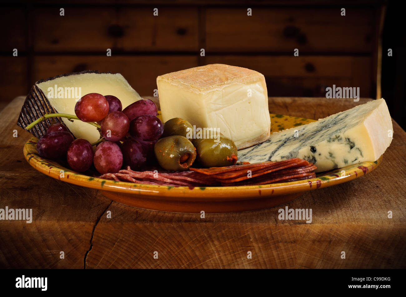 Small antipasti platter of mostly Italian cheeses and meats with olives ...