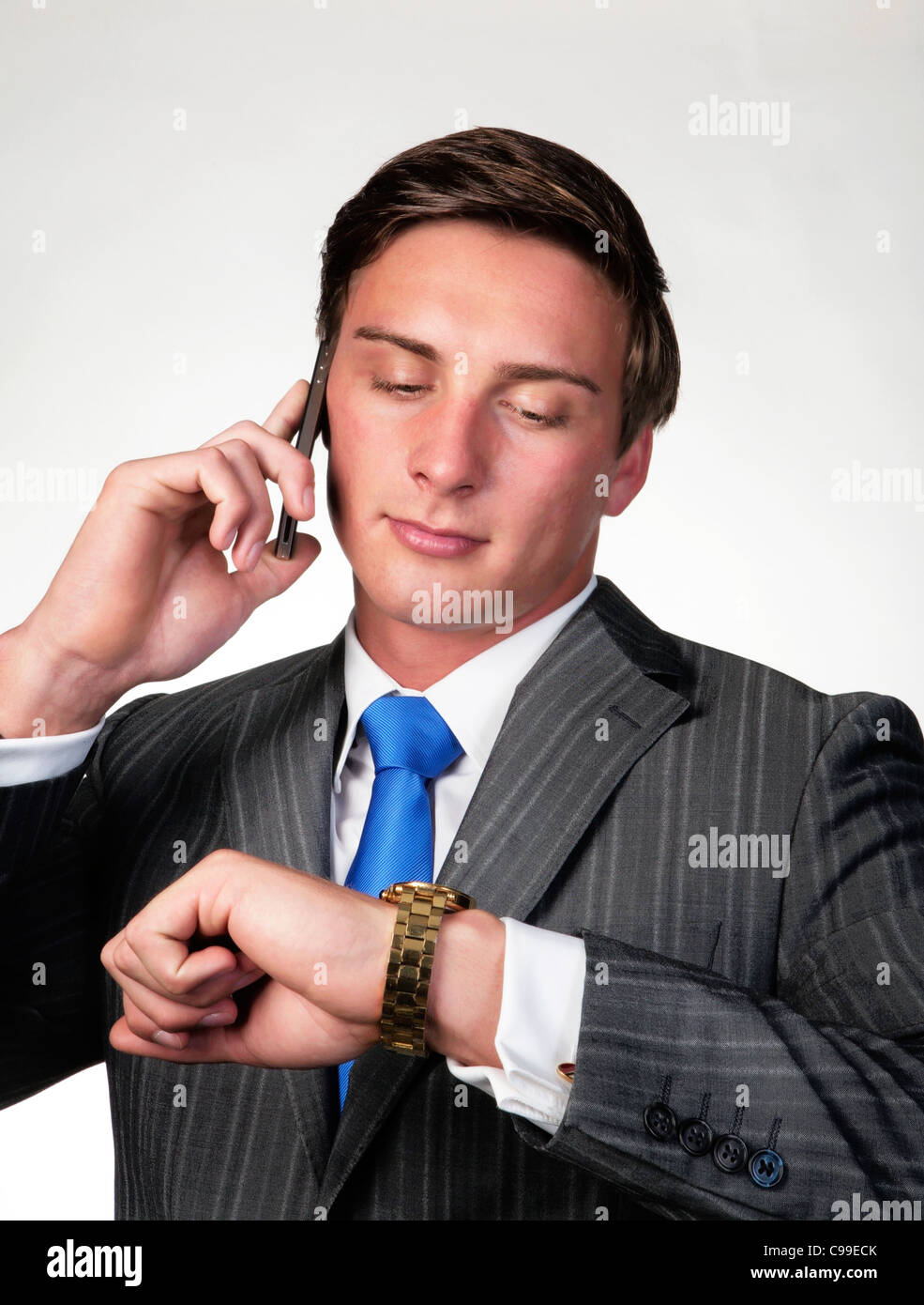 man on his mobile phone looking at his watch Stock Photo - Alamy