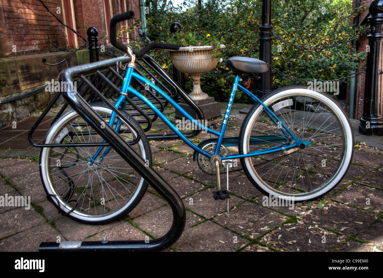 Bicycle resting in bike rack Stock Photo - Alamy