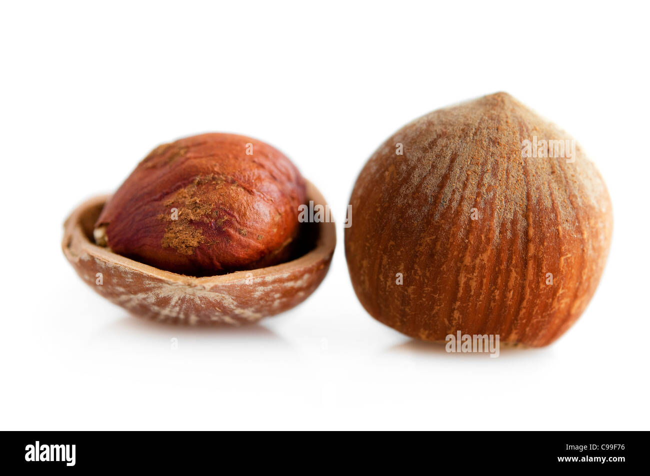 Closeup of whole and cracked hazelnuts. Isolated on white background ...