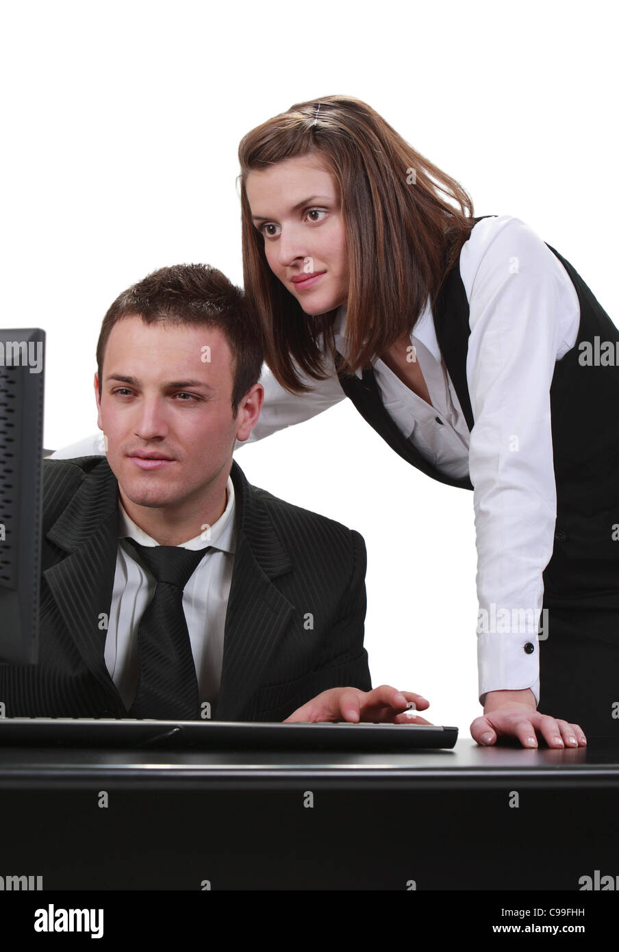 Young couple looking together to a computer, isolated against a white ...
