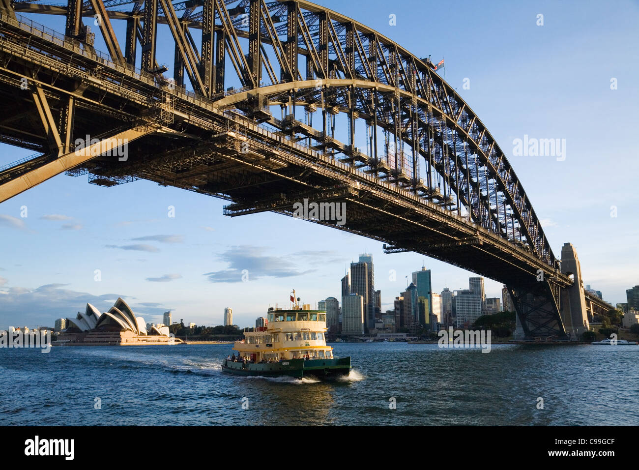 A ferry passes under the Sydney Harbour Bridge at Milson's Point ...