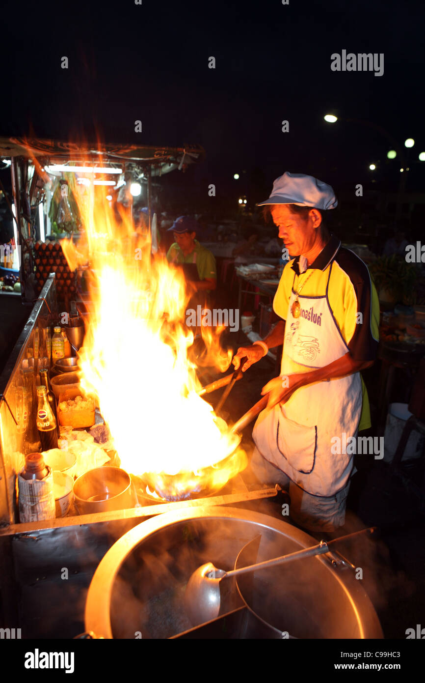 Thai man cooking over flaming wok at the Krabi River night market Stock ...