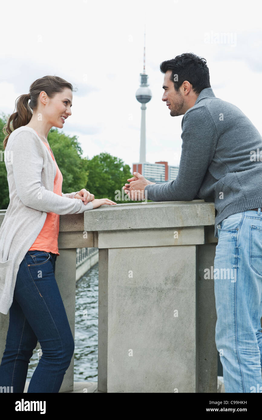 Germany, Berlin, Couple standing on bridge and talking Stock Photo - Alamy